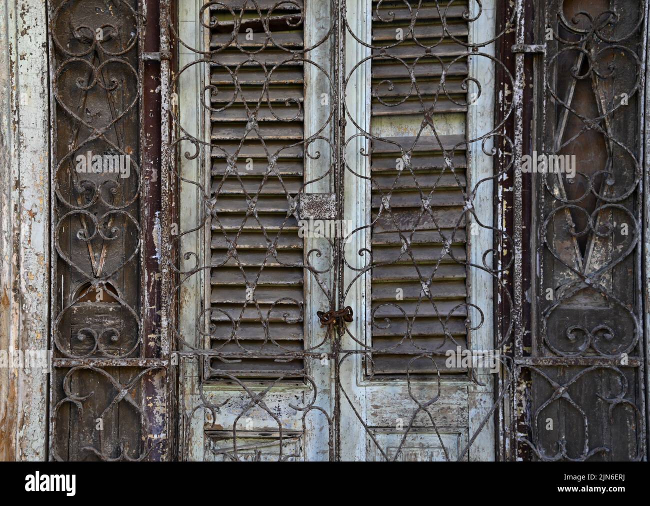 Antique window with wooden shutters and rusty handcrafted wrought iron ...