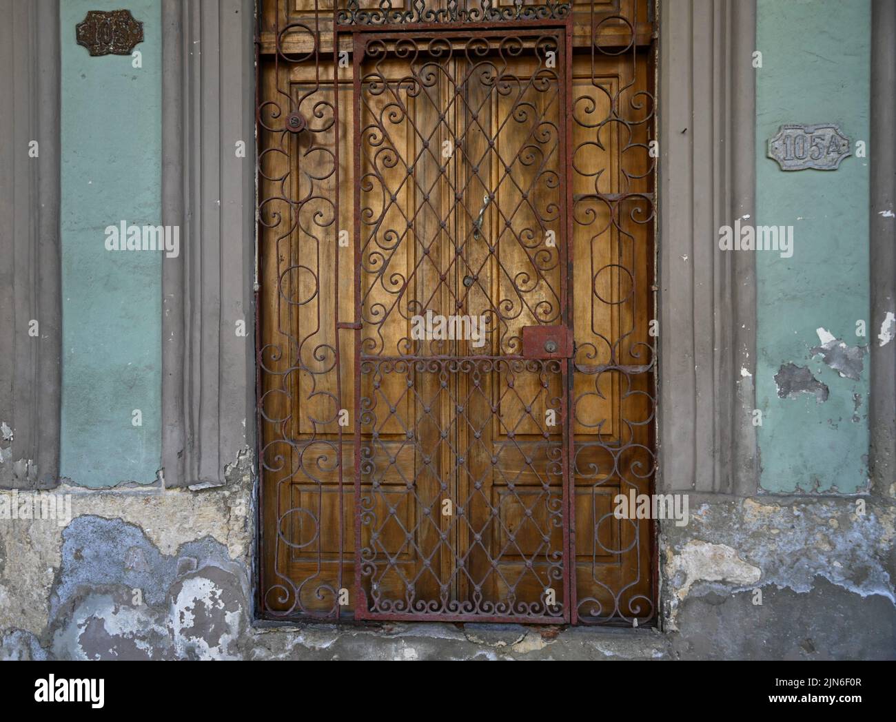 Antique hand carved wooden door with wrought iron grilles on a ...