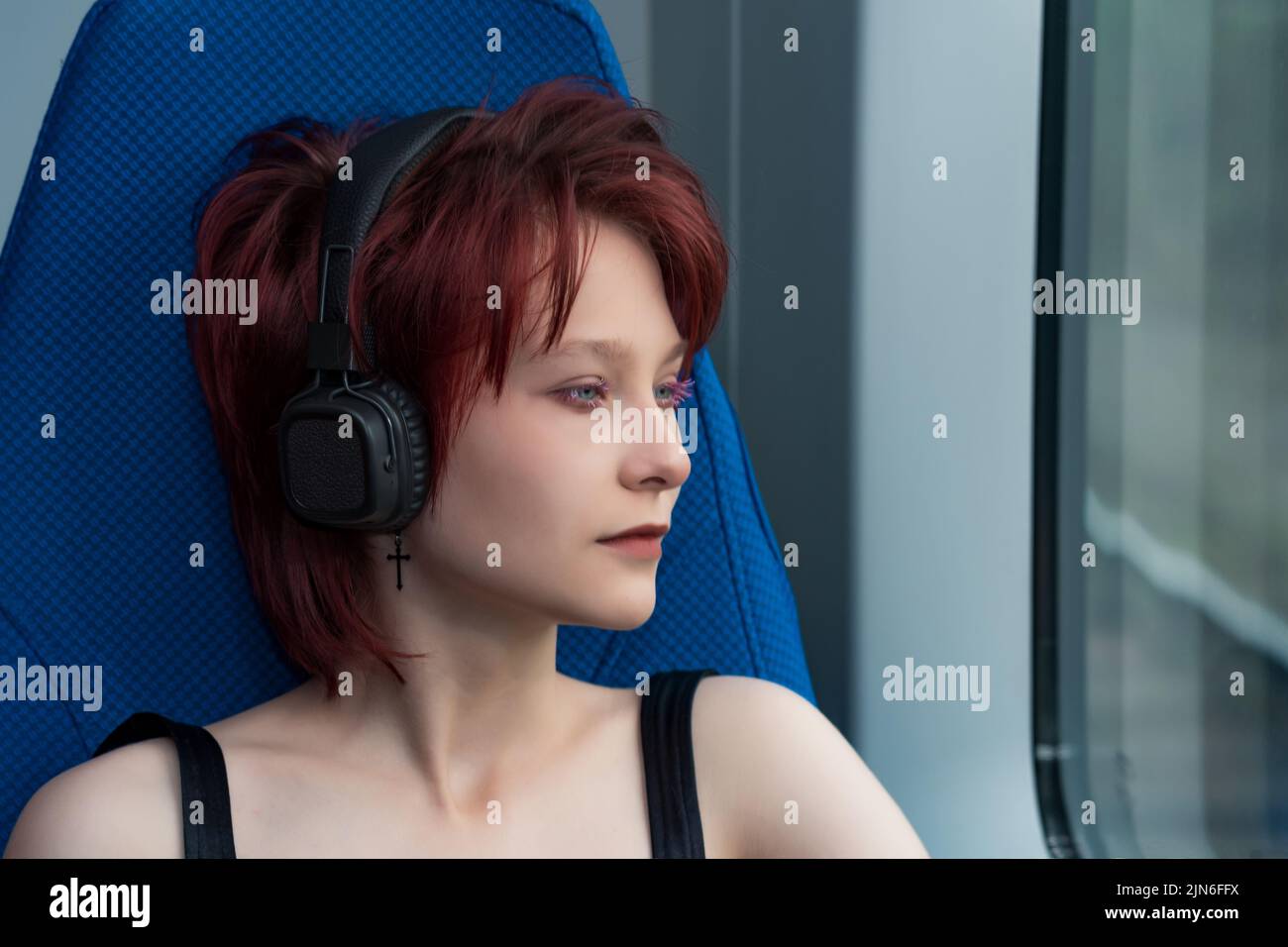 young woman listening to music with headphones while riding on a high ...