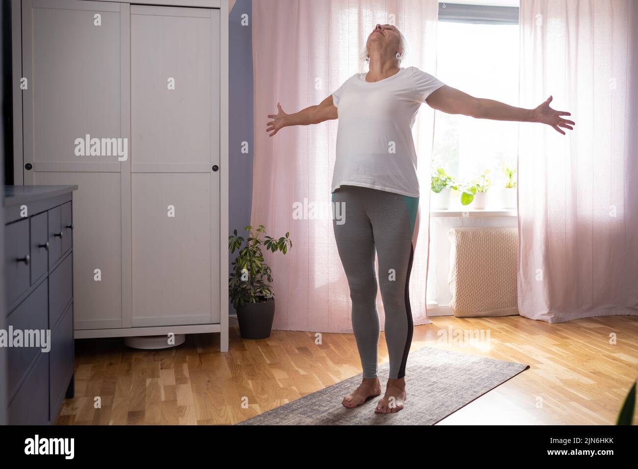 Senior woman working out indoors stretching muscles Stock Photo - Alamy