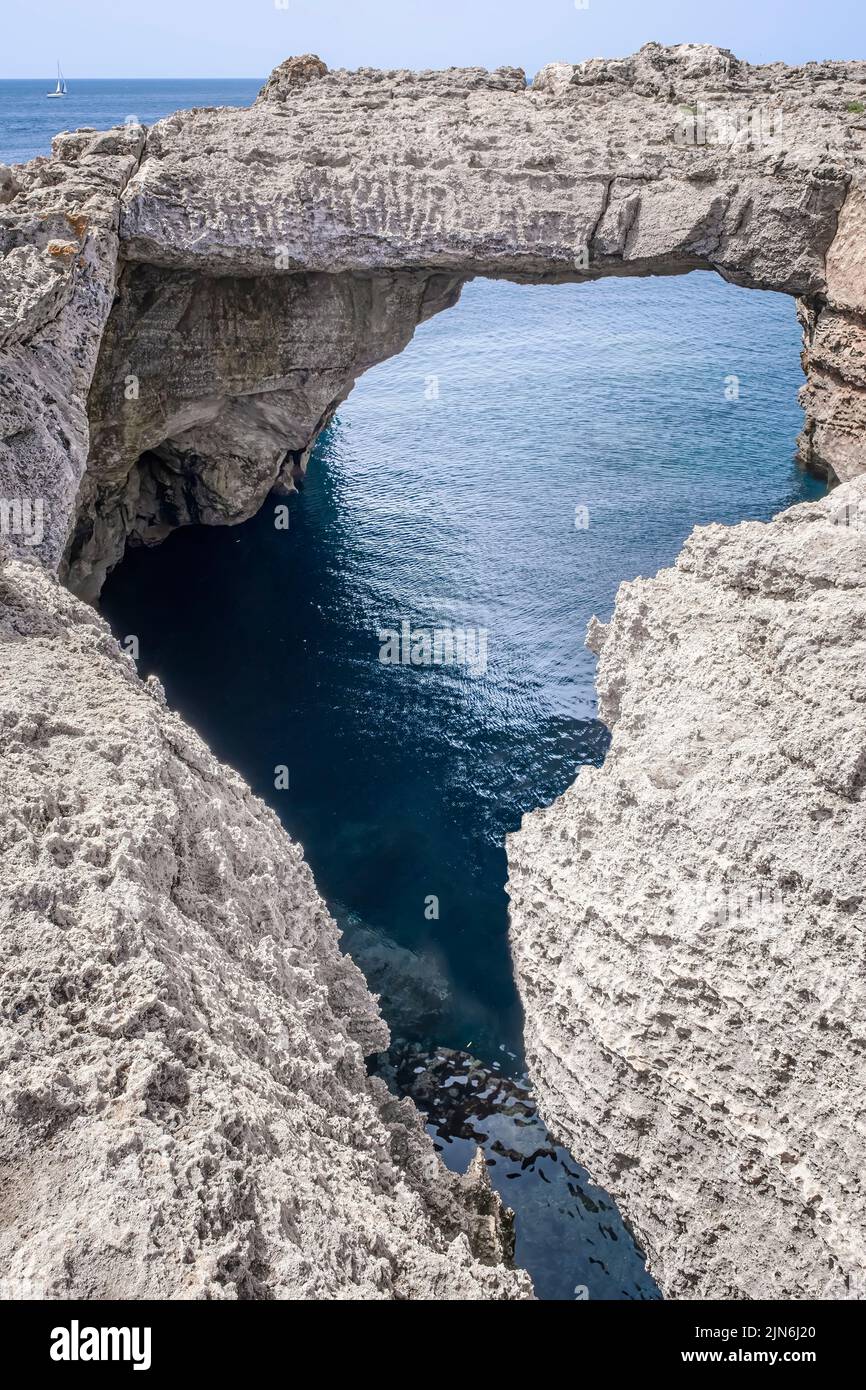 rocky grotto in a cliff forming a natural bridge or natural bow over ...