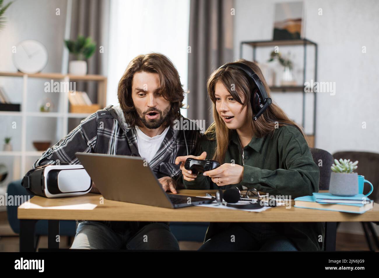 Portrait of excited focused young girl in headset playing in video game ...