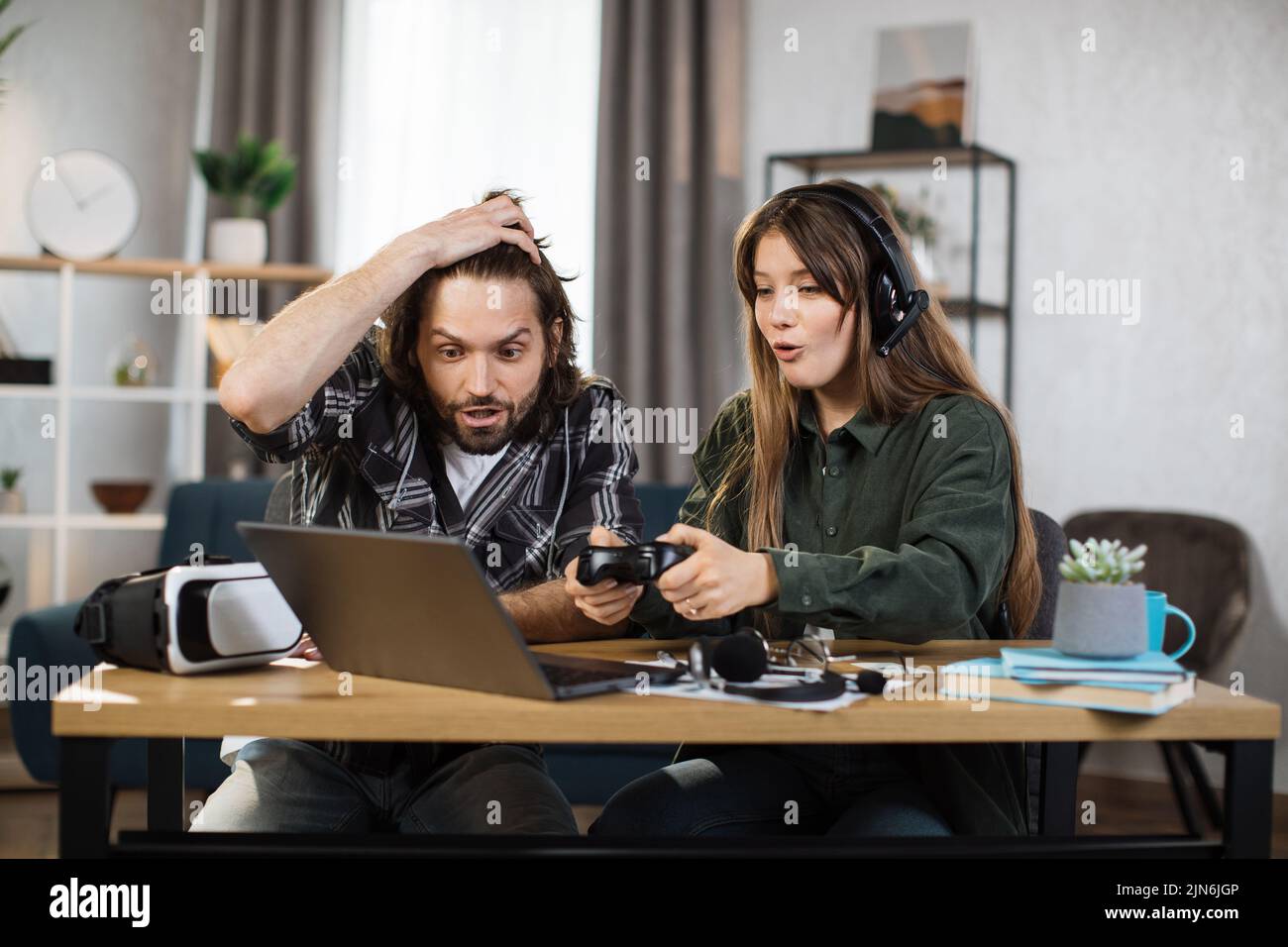 Portrait of excited focused young girl in headset playing in video game ...