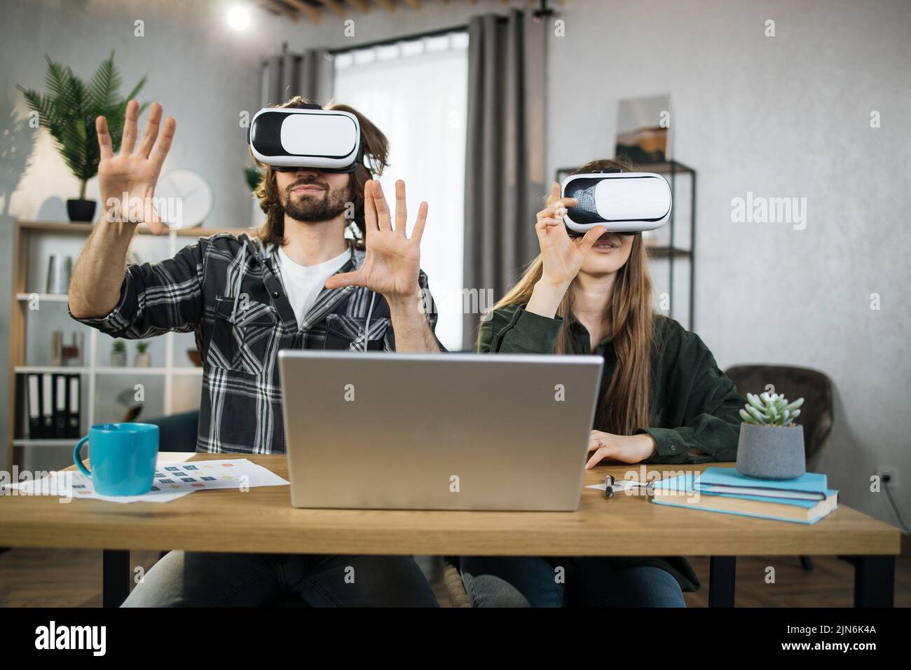 Excited young people with surprised expression, playing games at home ...