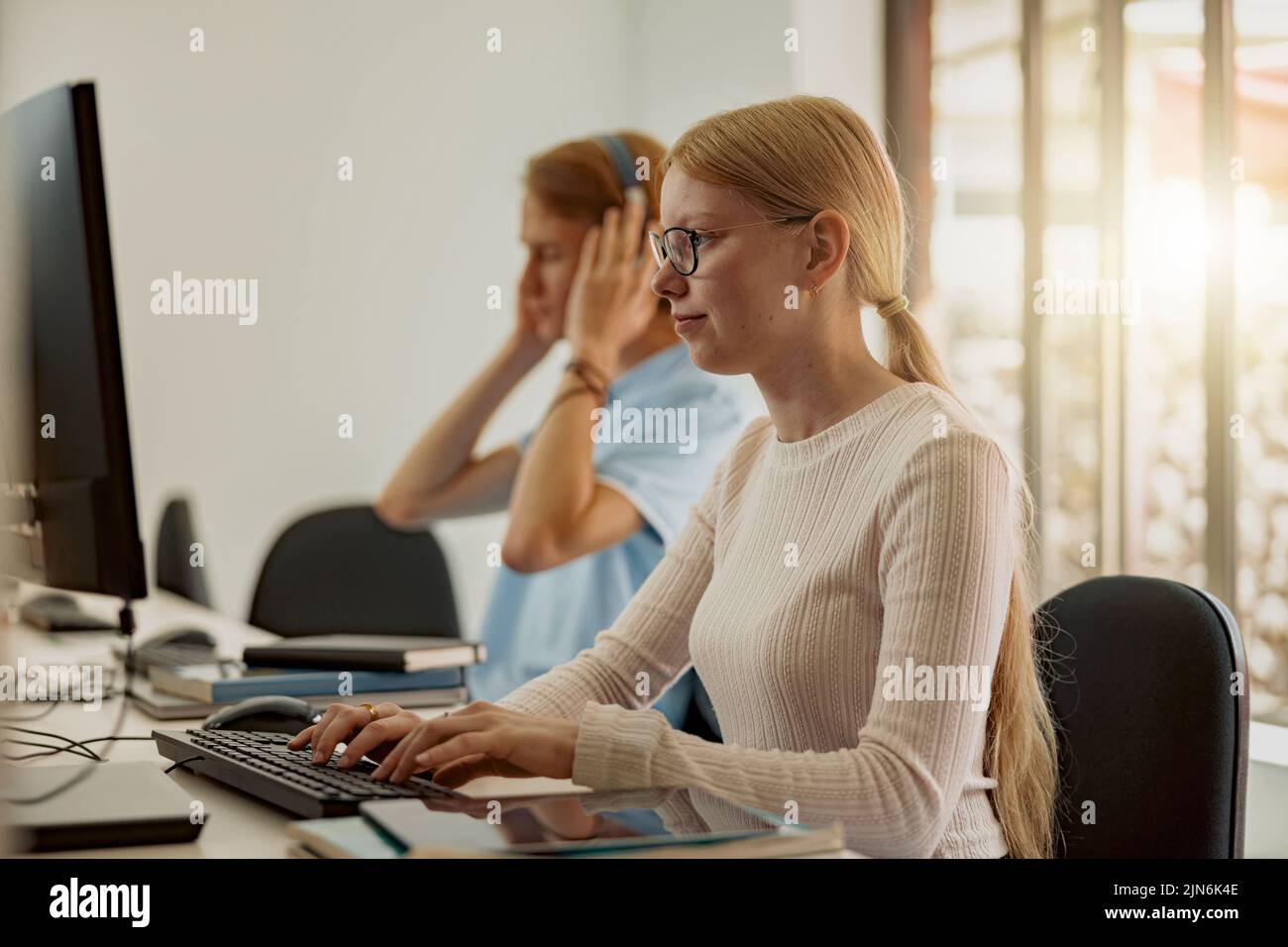 Focused university student using computer studying in computer room ...