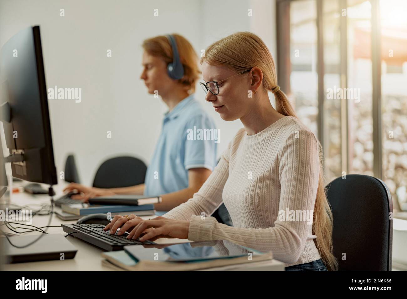 Focused university student using computer studying in computer room ...