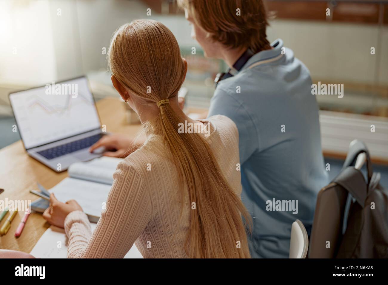 Two talented students working together on university project sitting in ...