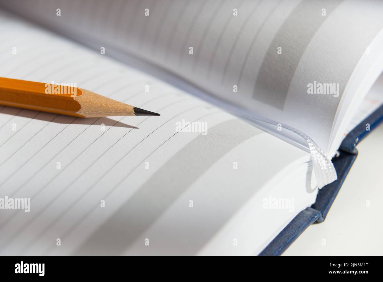 The wooden pencil is on the open diary Stock Photo - Alamy