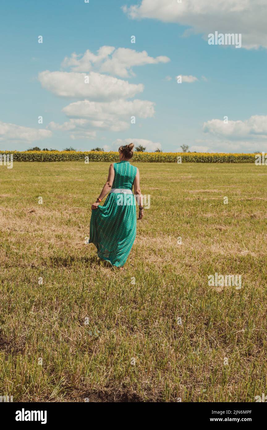 Woman walking through field sunflowers hi-res stock photography and ...