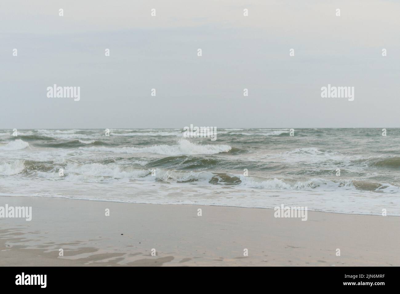 Rough waves crashing into the sand on the seashore on the North ...