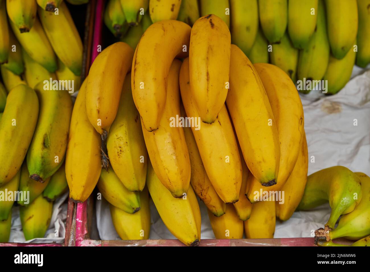 Hanging bananas placed on a shelf for sale within a market Stock Photo ...