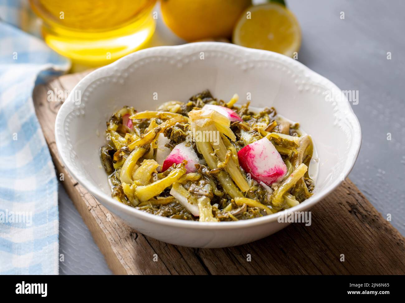 Green vegetables are served with red radish. Olive oil dish Stock Photo ...