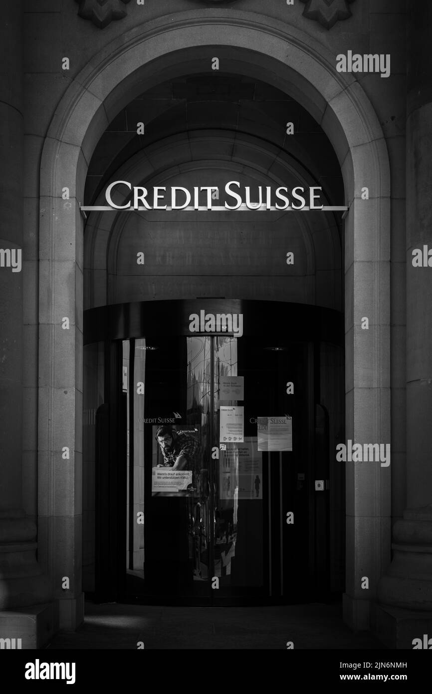A vertical shot of black and white Credit Suisse logo above building ...