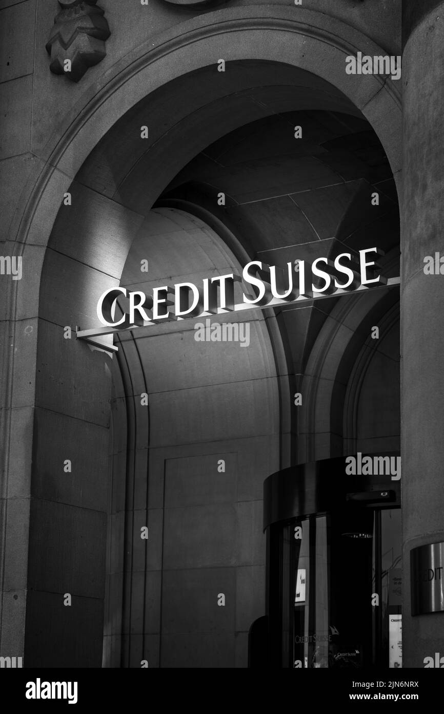 A vertical shot of black and white Credit Suisse logo above building ...