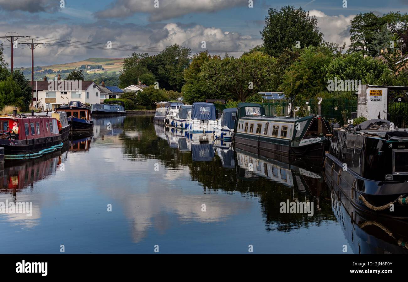 Barges and small sailing boats moored up at the side of the Leeds ...