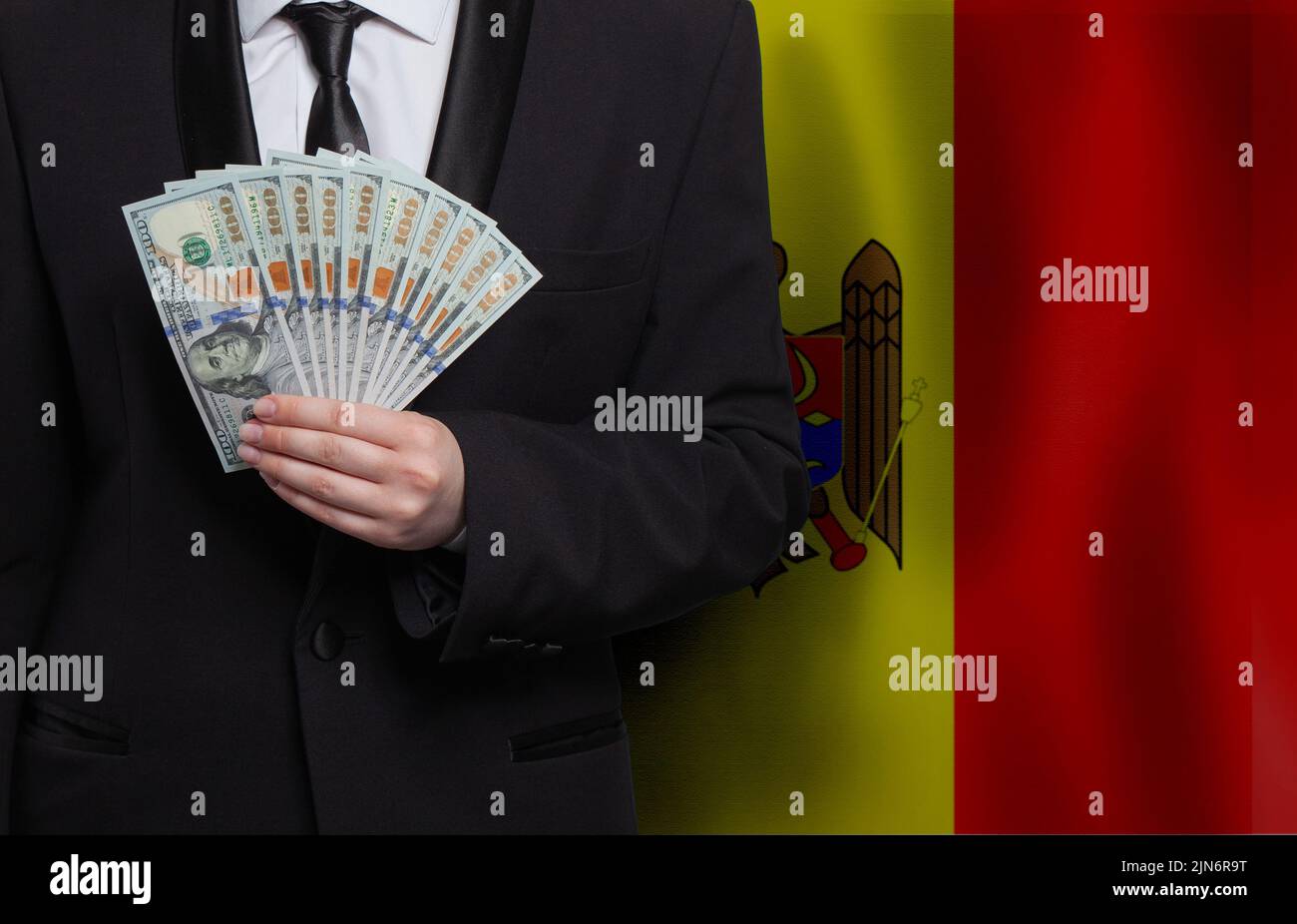 Moldavian Man With 100 US Dollar Bills Money Banknotes Against Flag Of moldavian-man-with-100-us-dollar-bills-money-banknotes-against-flag-of