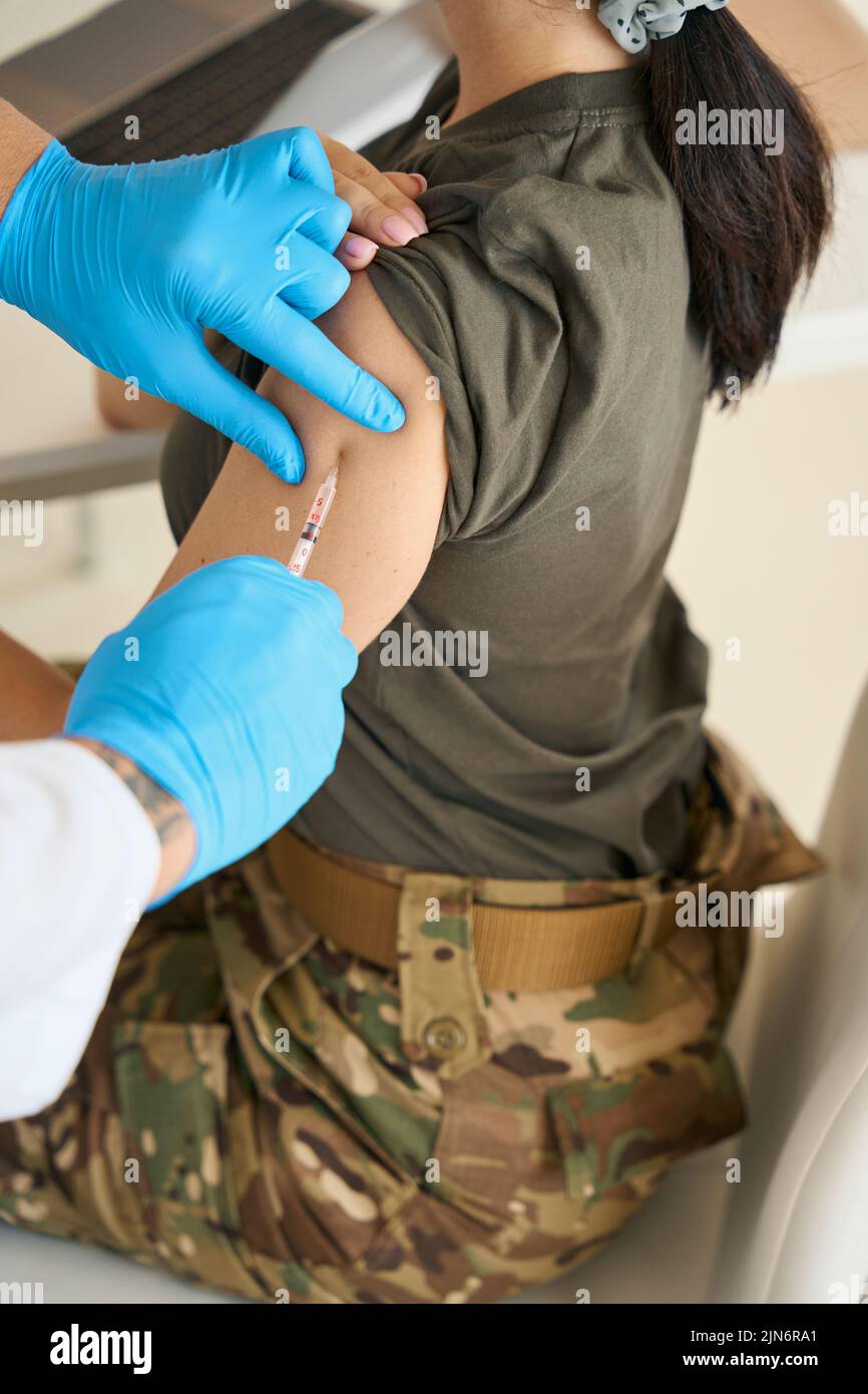 Soldier woman getting a vaccine injection at a medical station Stock ...