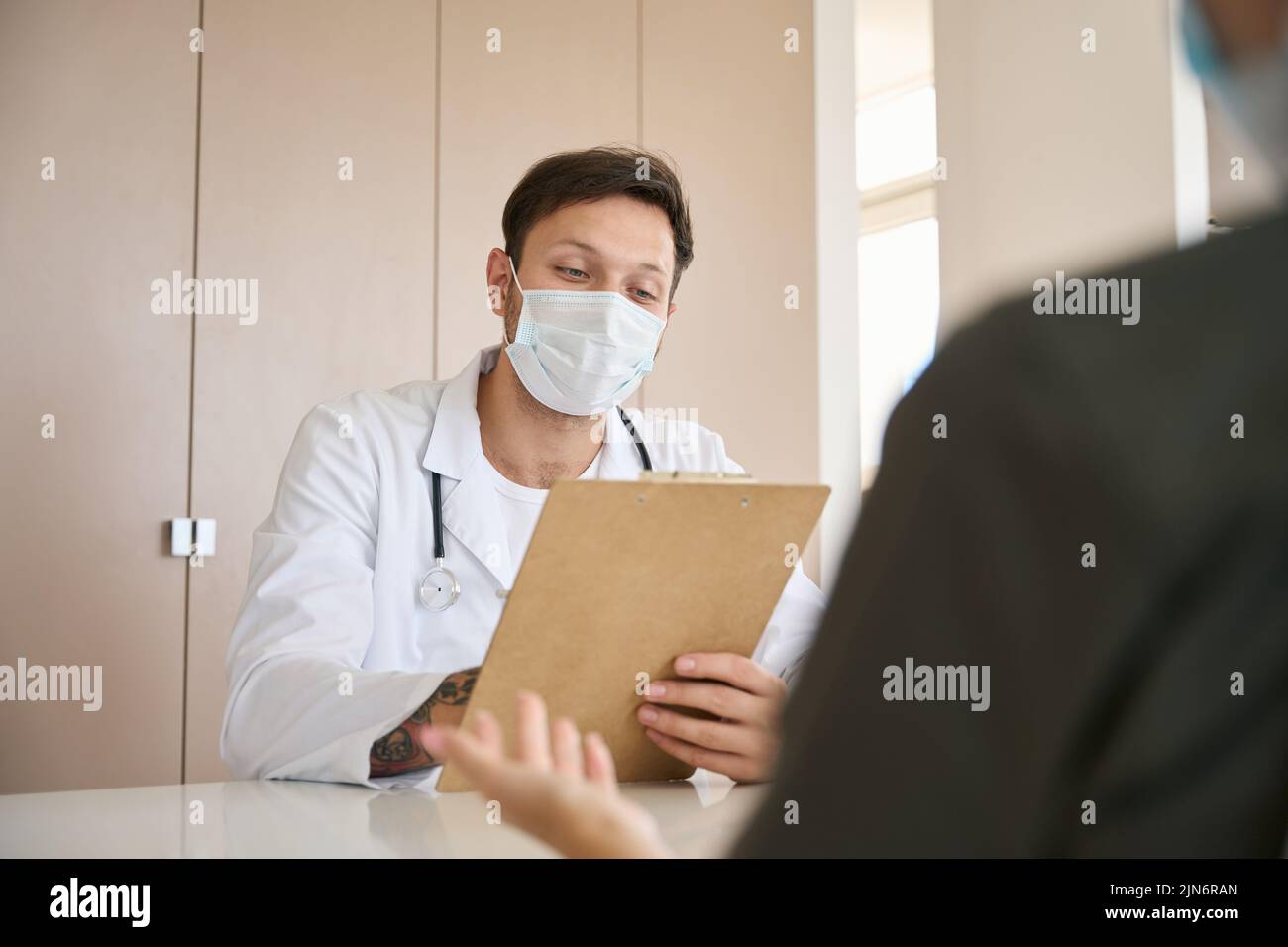Doctor looks at the patient's medical history Stock Photo - Alamy