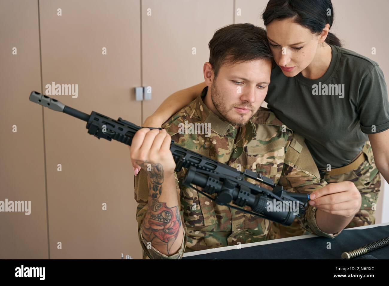 Military man holds weapon in his hands and examines it Stock Photo - Alamy