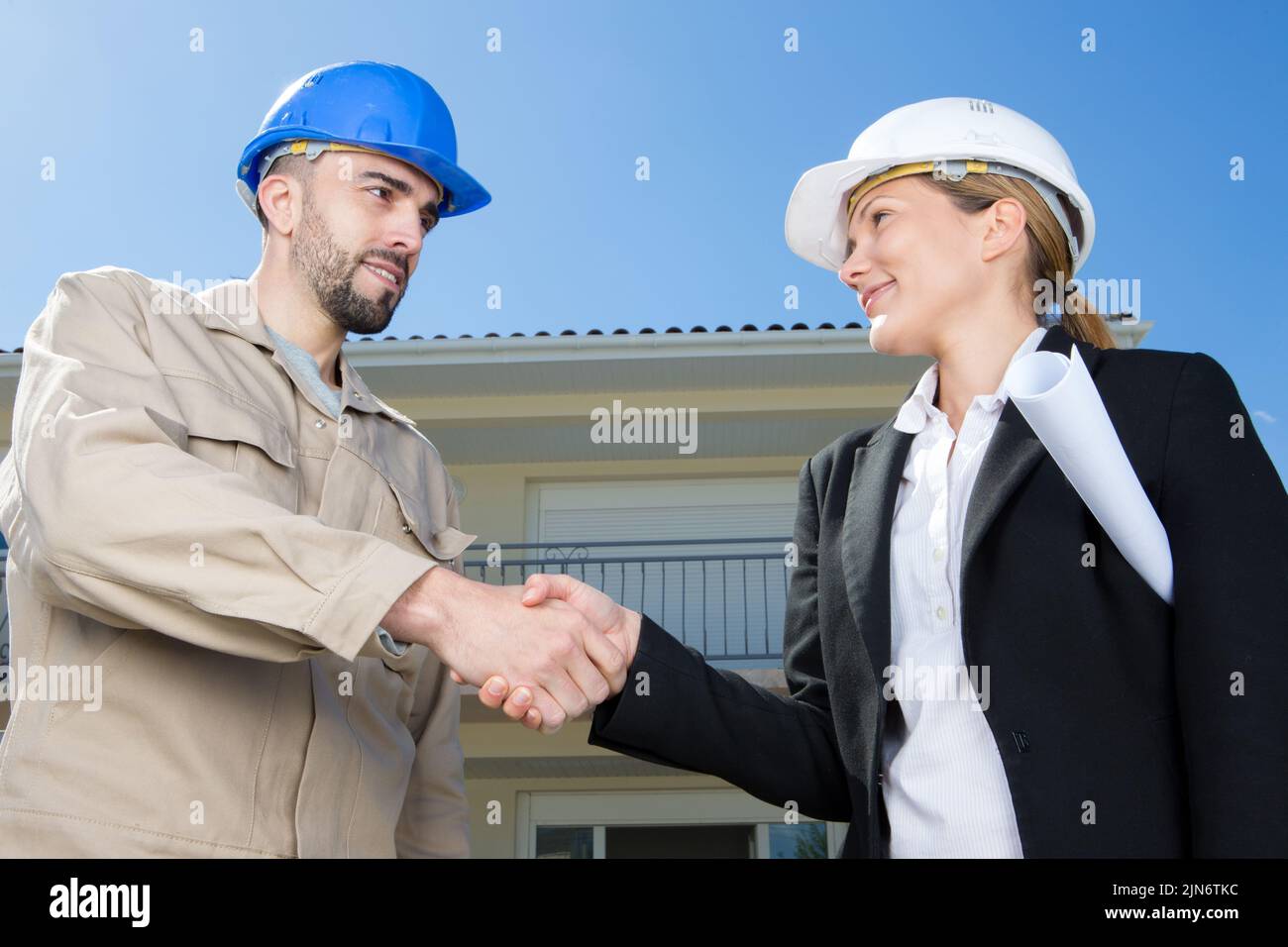 female architect handshakes male builder Stock Photo - Alamy