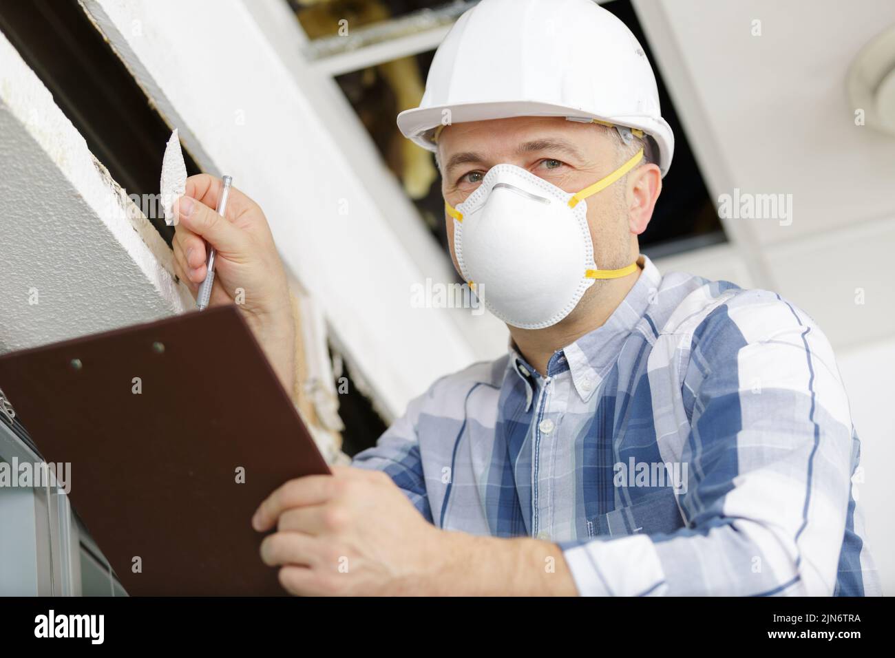 male builder in hard hat holds clipboard Stock Photo - Alamy