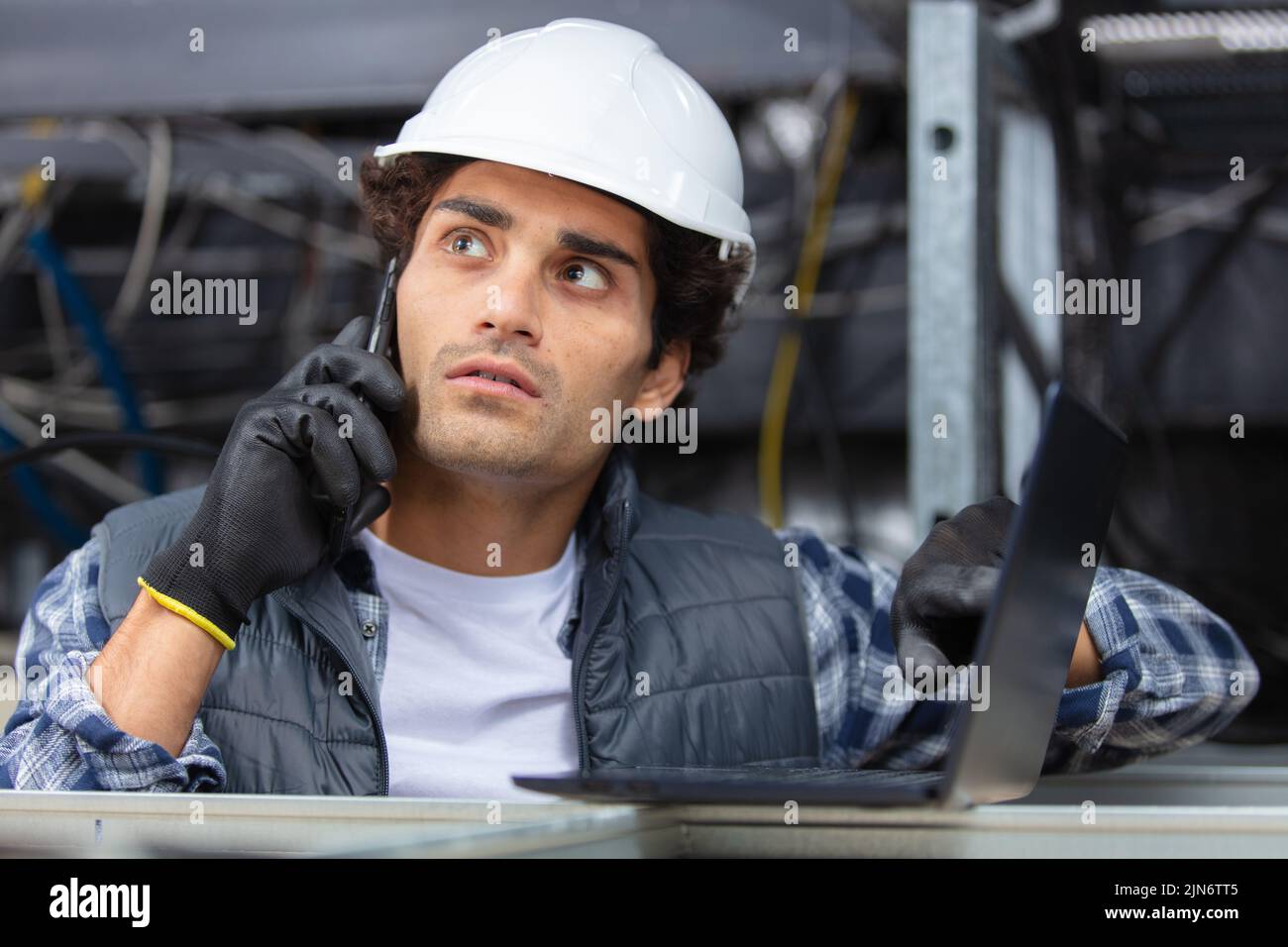 builder on cell phone on elevated scaffolding in ceiling Stock Photo ...