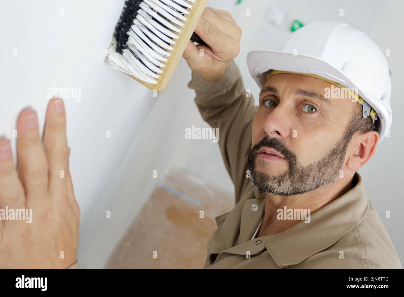 worker painting wall in room Stock Photo - Alamy