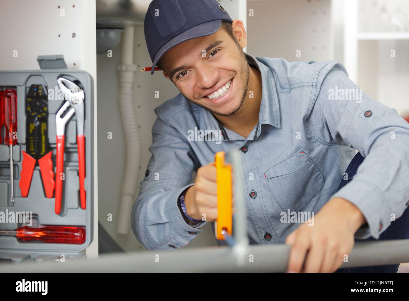happy plumber sawing plastic pipe Stock Photo - Alamy