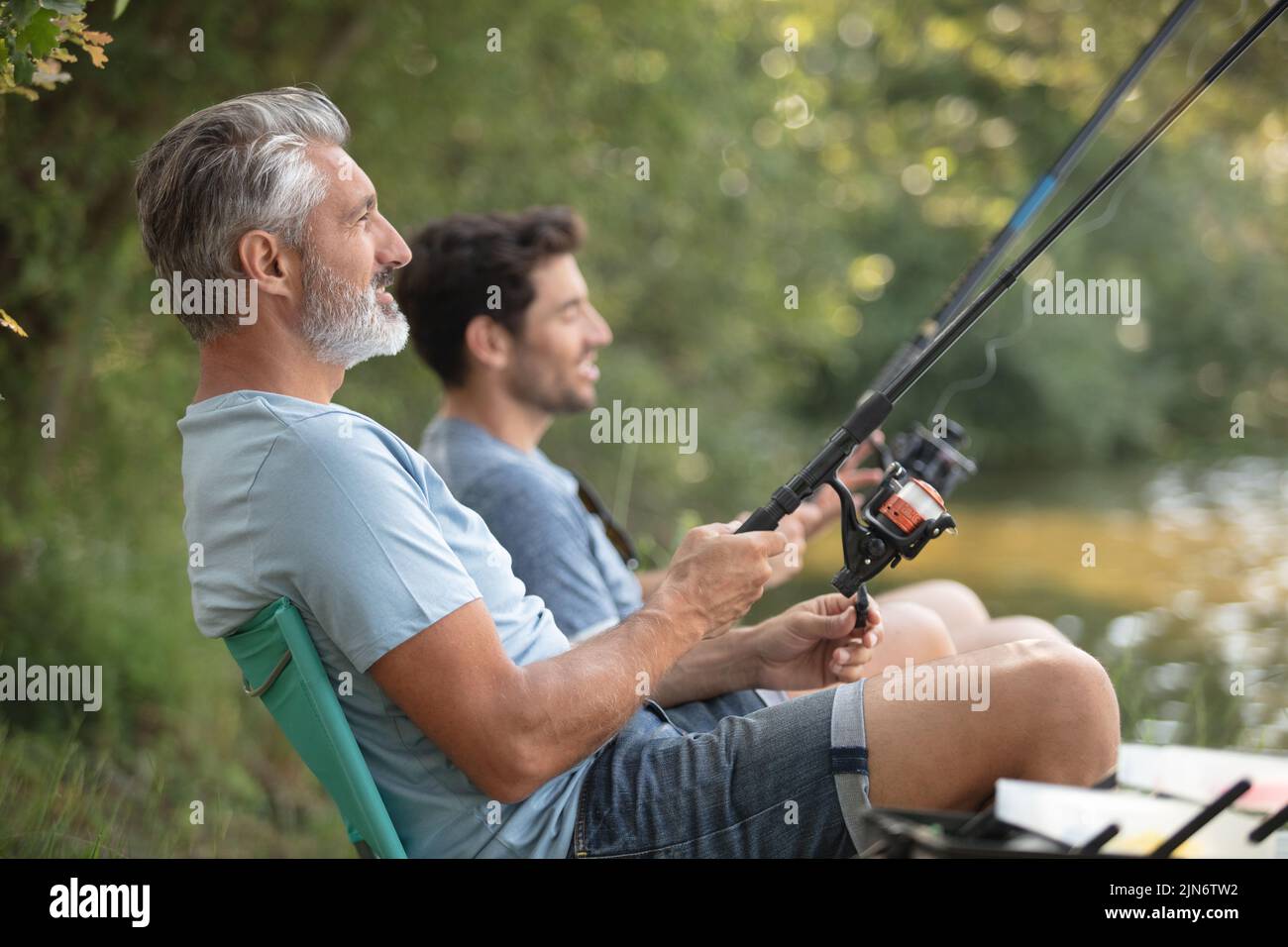 two male friends are fishing together Stock Photo - Alamy