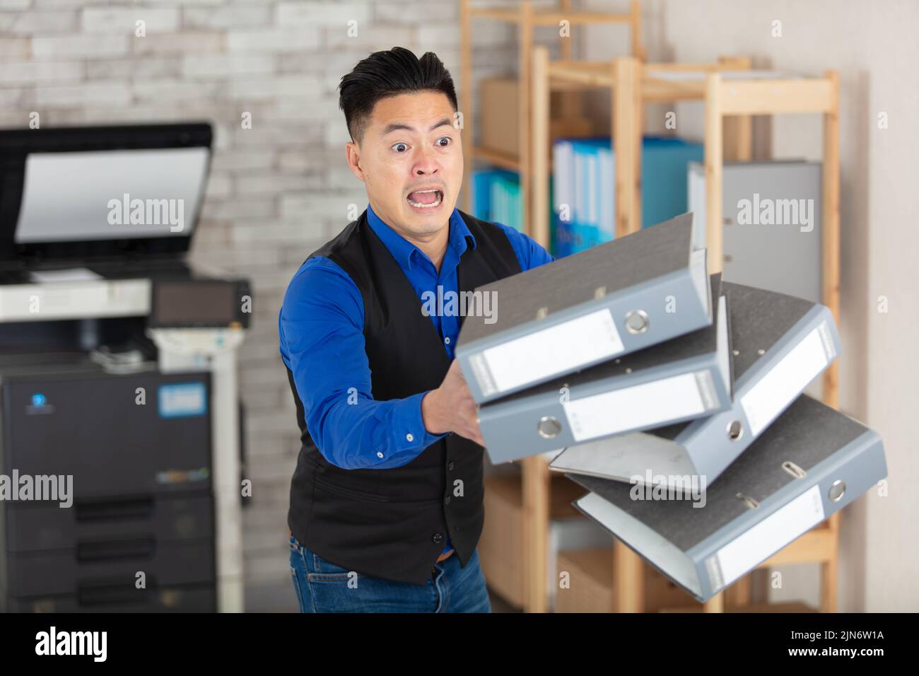 office workers with falling folders in office Stock Photo - Alamy