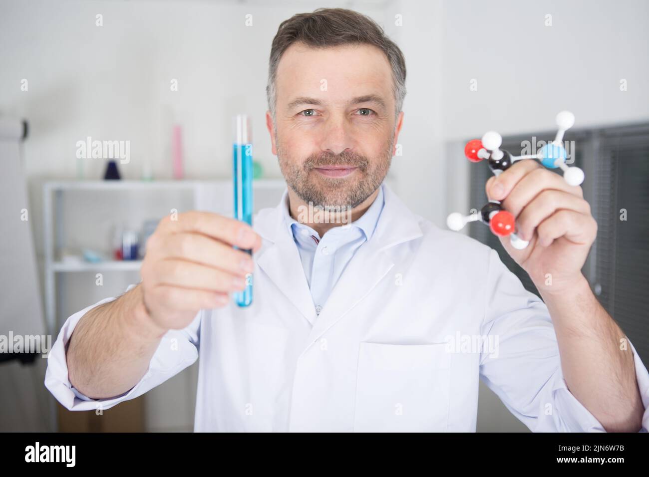 male scientist holding test-tube and model molecule Stock Photo - Alamy