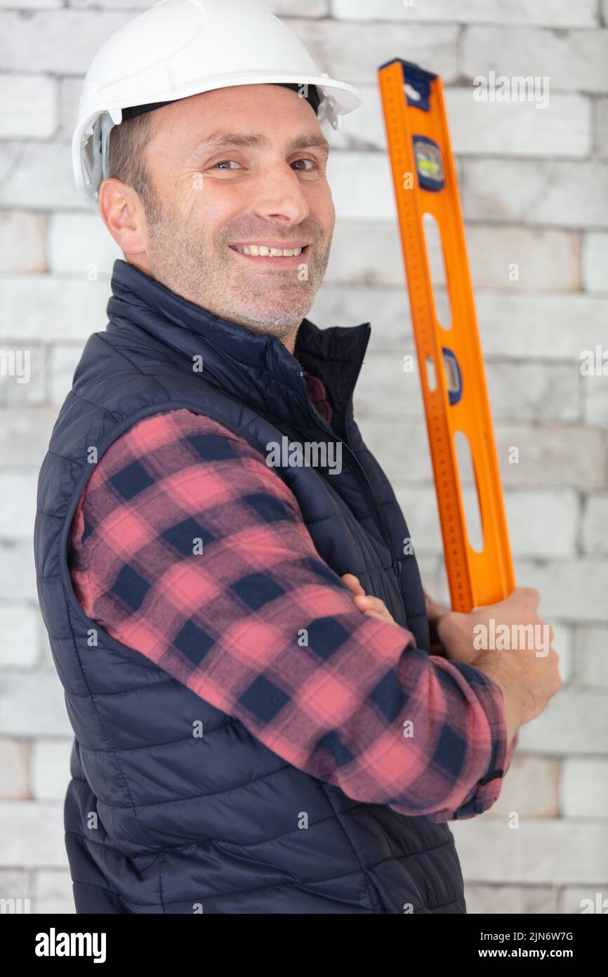 portrait of builder on site with level Stock Photo - Alamy