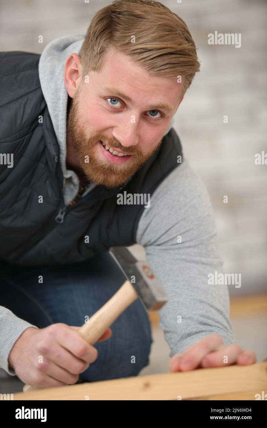 happy man hammering nails into wooden planks Stock Photo - Alamy