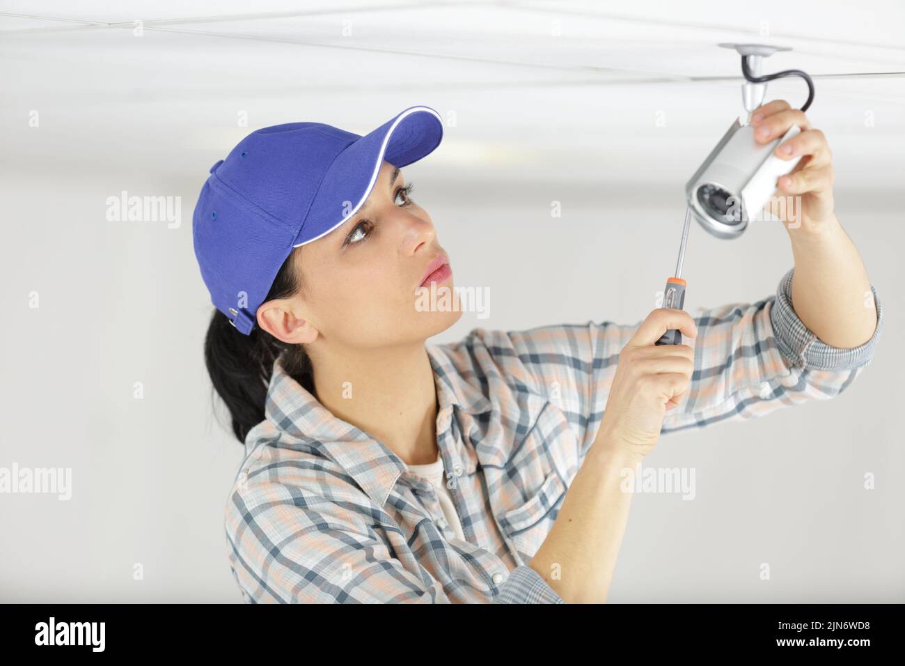 female cctv installer checking security camera Stock Photo - Alamy