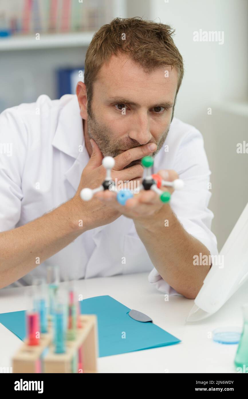 picture of a man in the lab holding atom model Stock Photo - Alamy