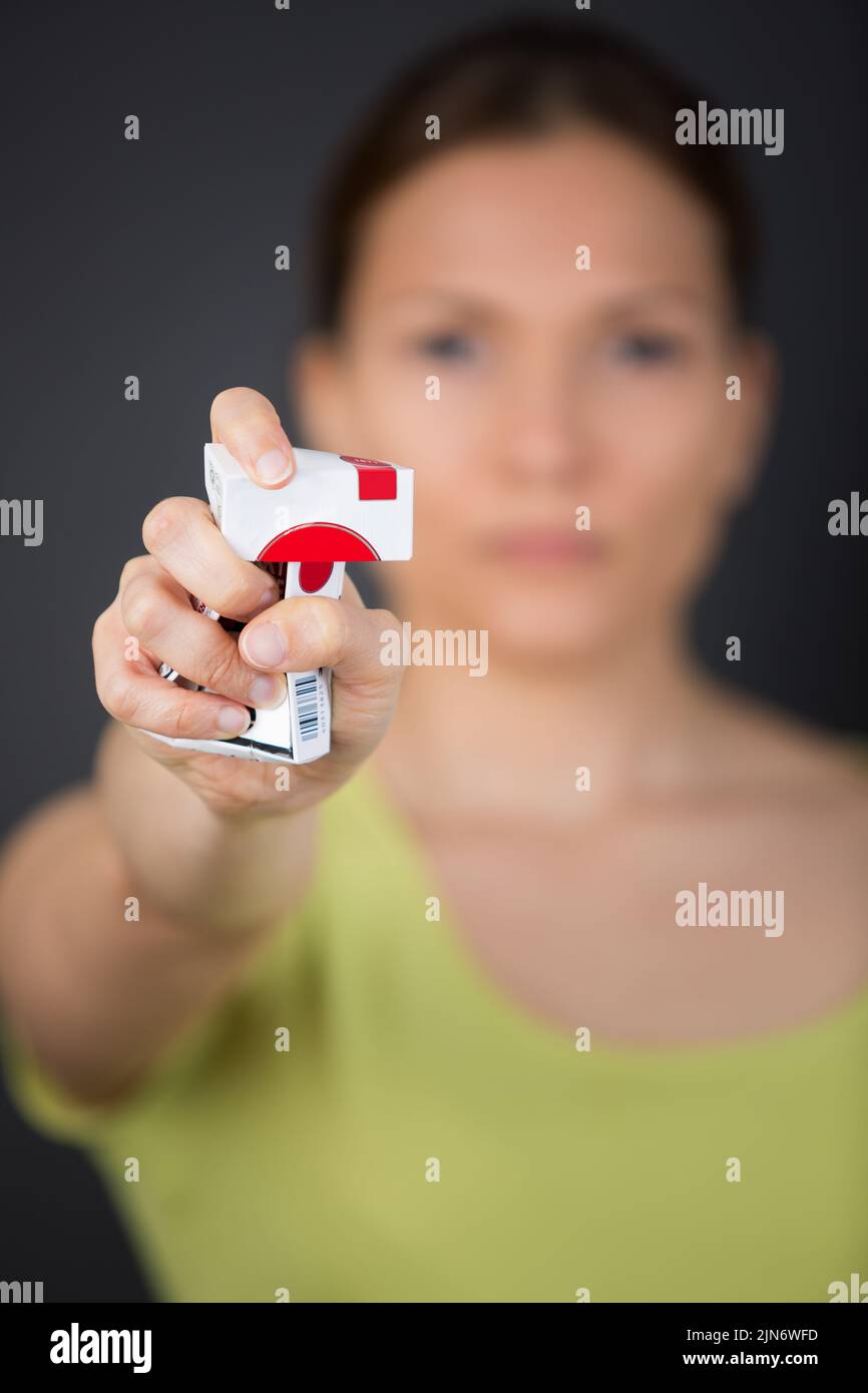 woman crushing cigarette packet in outstretched hand Stock Photo - Alamy