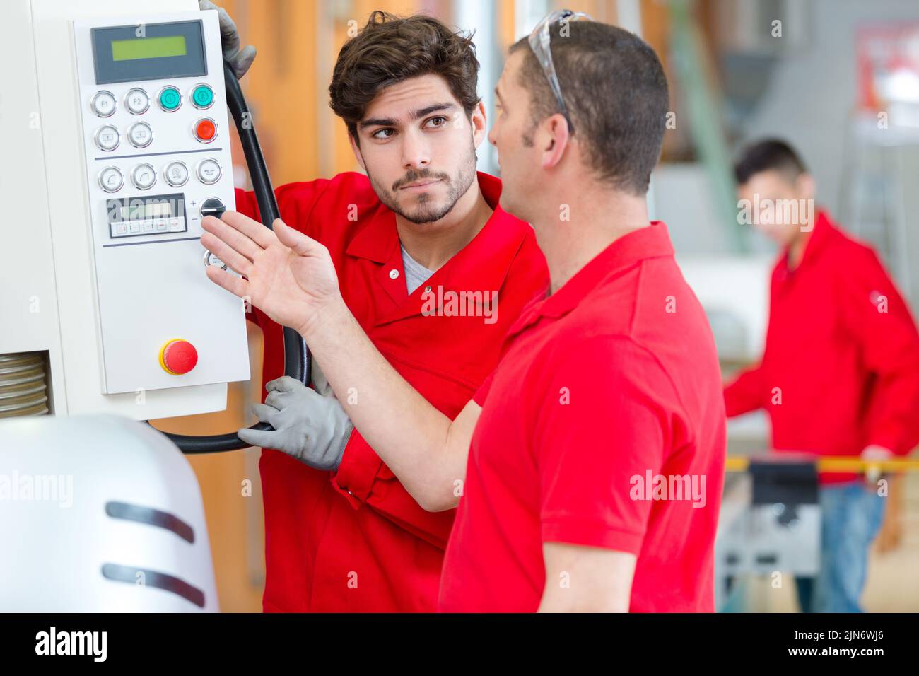 workers operating a machine in a factory Stock Photo - Alamy