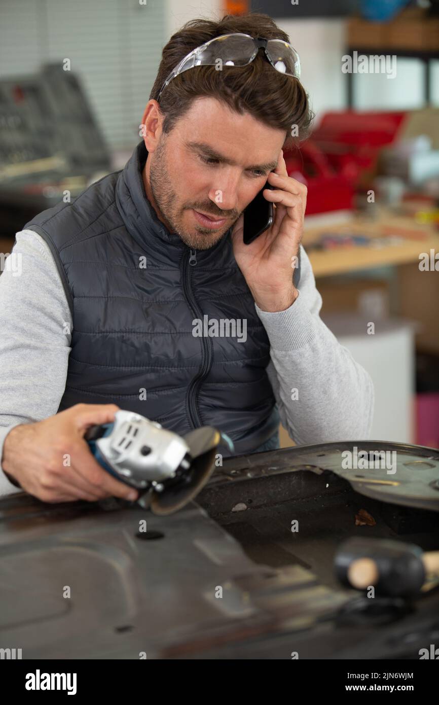 workman using an angle grinder on a car door Stock Photo - Alamy