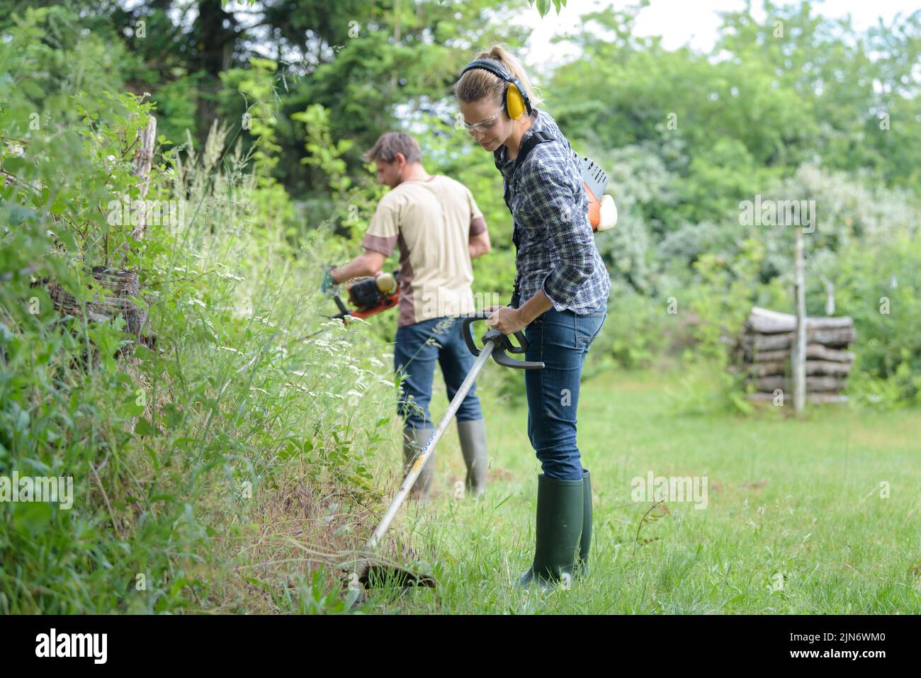 two people mowing the grass Stock Photo - Alamy
