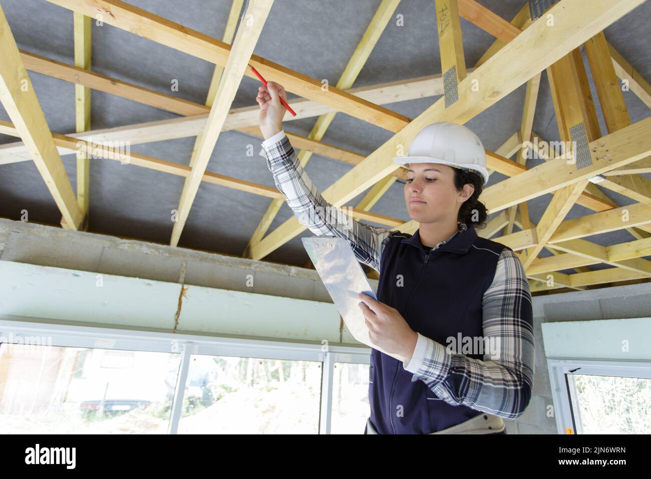 female worker inspecting wooden timbers in property Stock Photo - Alamy