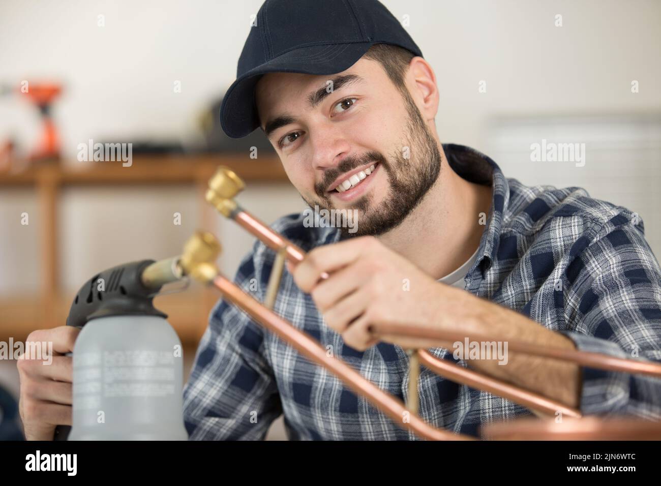 smiling plumber using welding gas torch to solder copper pipes Stock ...