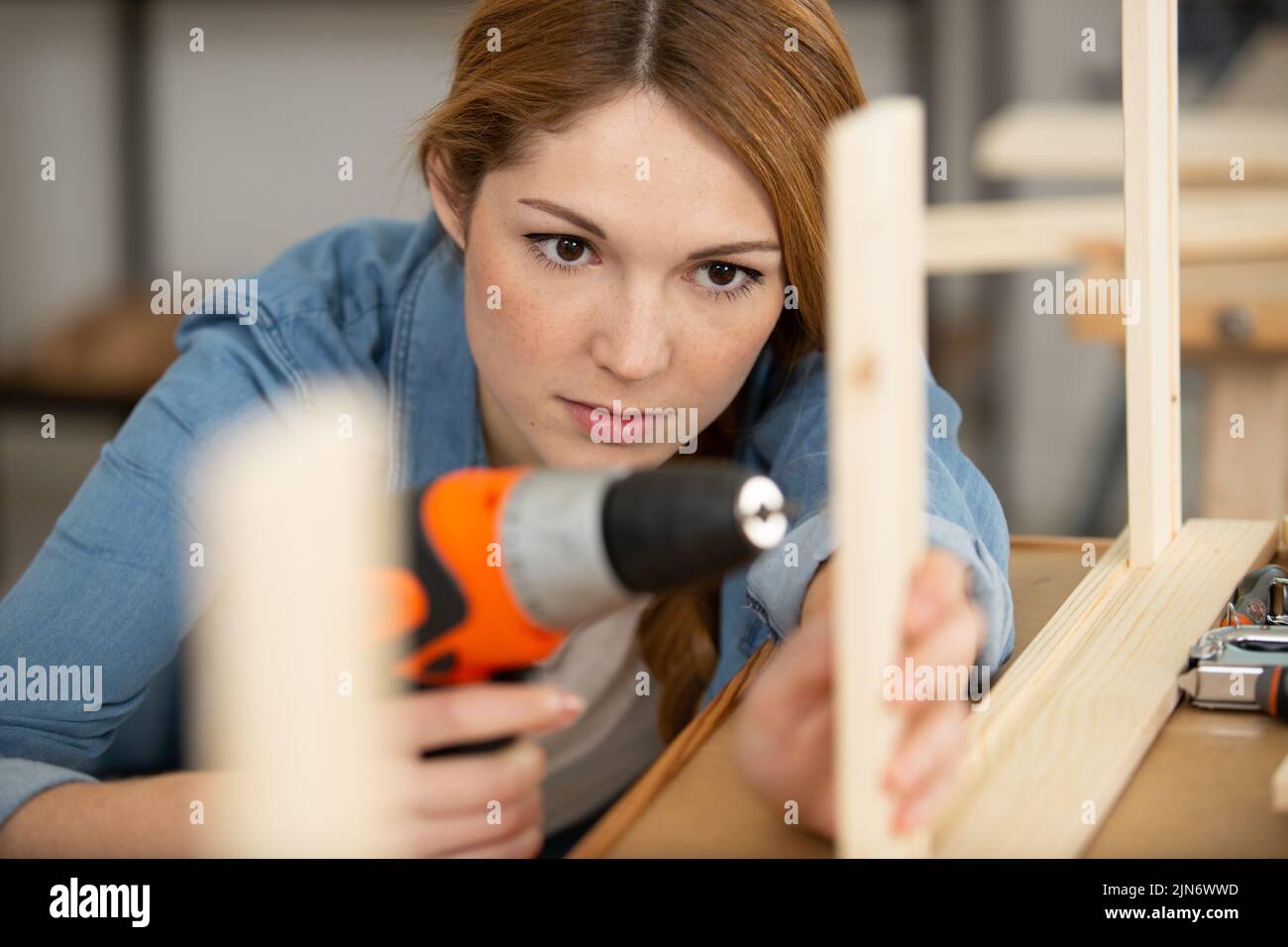 young woman carpenter using electric drill Stock Photo - Alamy