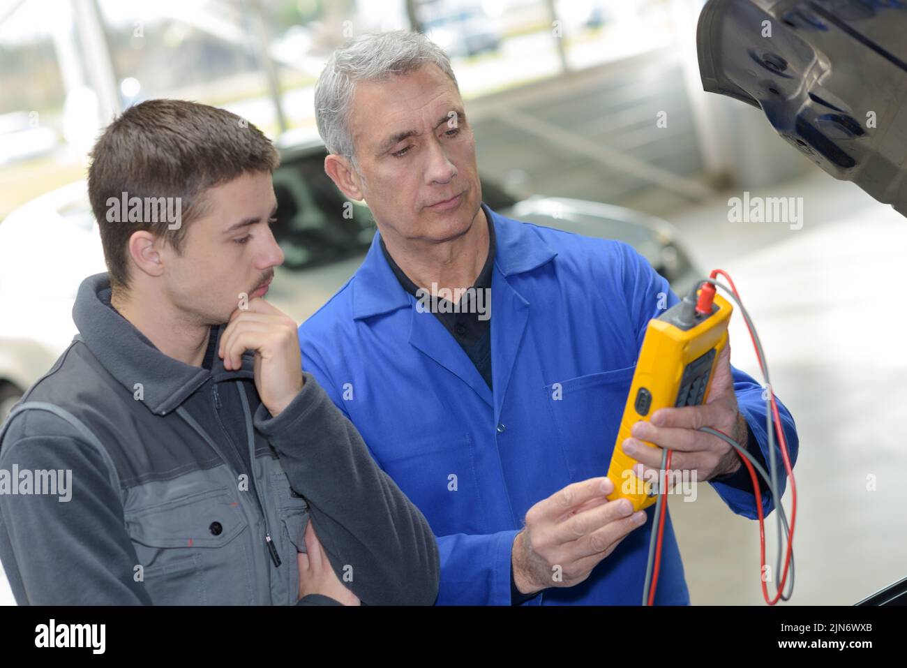 student with instructor repairing a car during apprenticeship Stock ...
