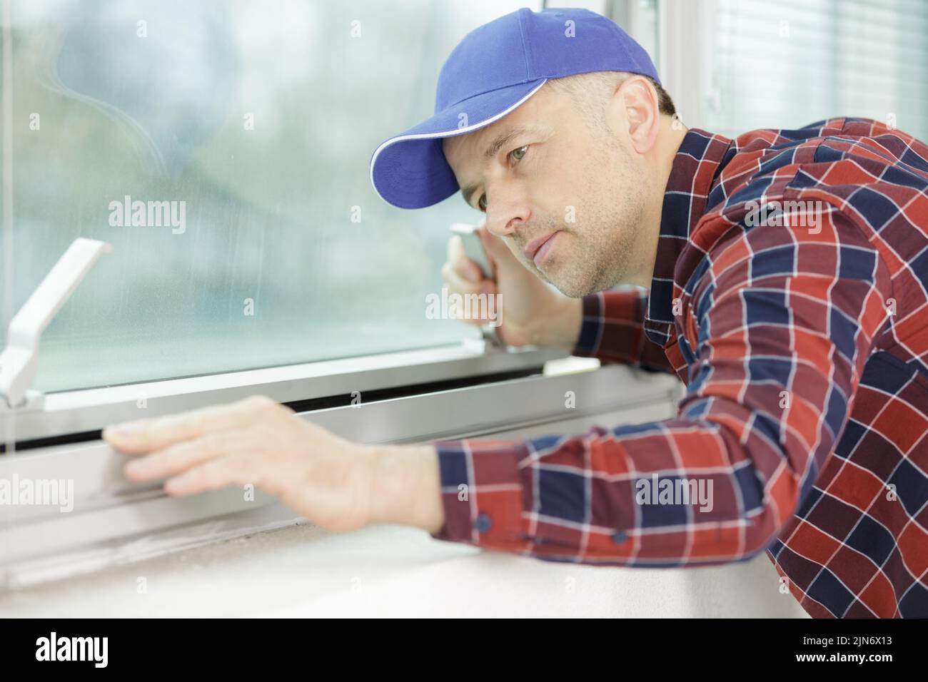 workman checking aluminium window frame Stock Photo - Alamy