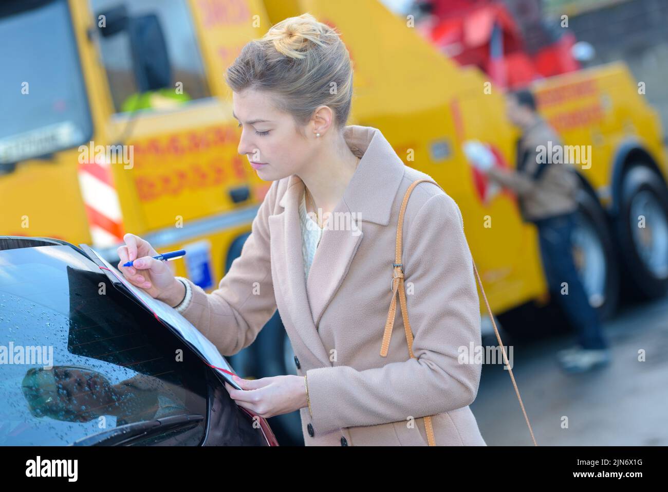 woman filling in car insurance form after car breakdown Stock Photo - Alamy
