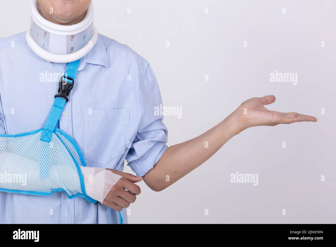 Portrait of Asian man with broken arm and neck showing empty space ...