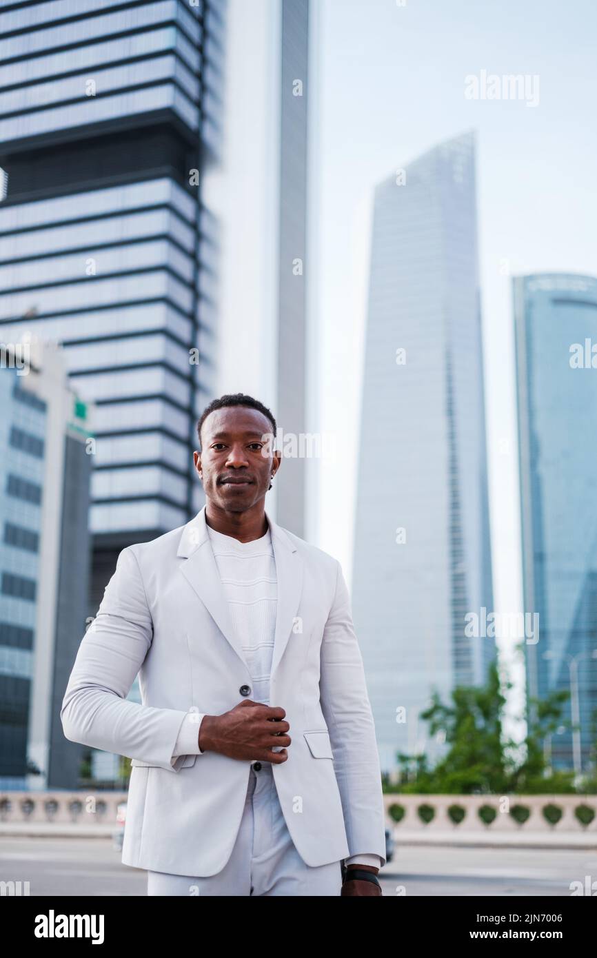 Successful businessman dressed in white suit in financial district ...