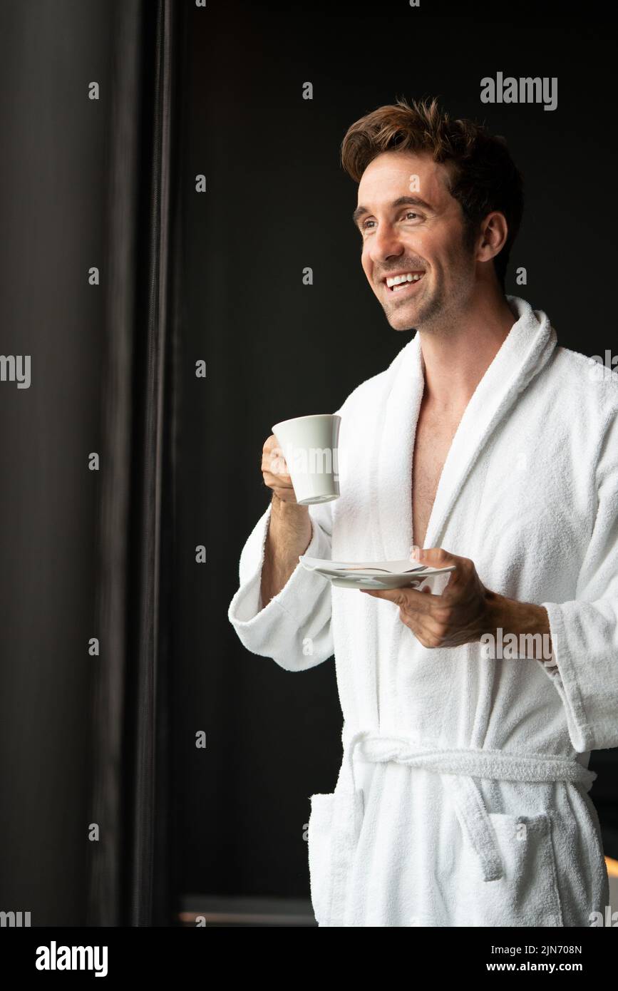Young man in bathrobe drinking coffee at home Stock Photo - Alamy
