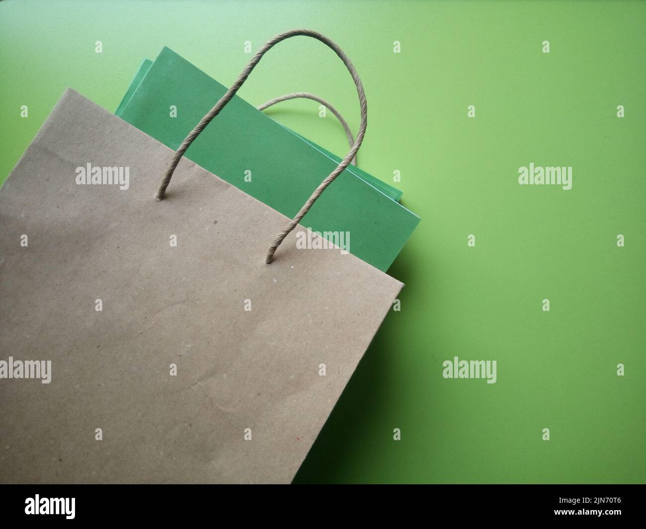 Paper shopping bag with books on green background Stock Photo - Alamy