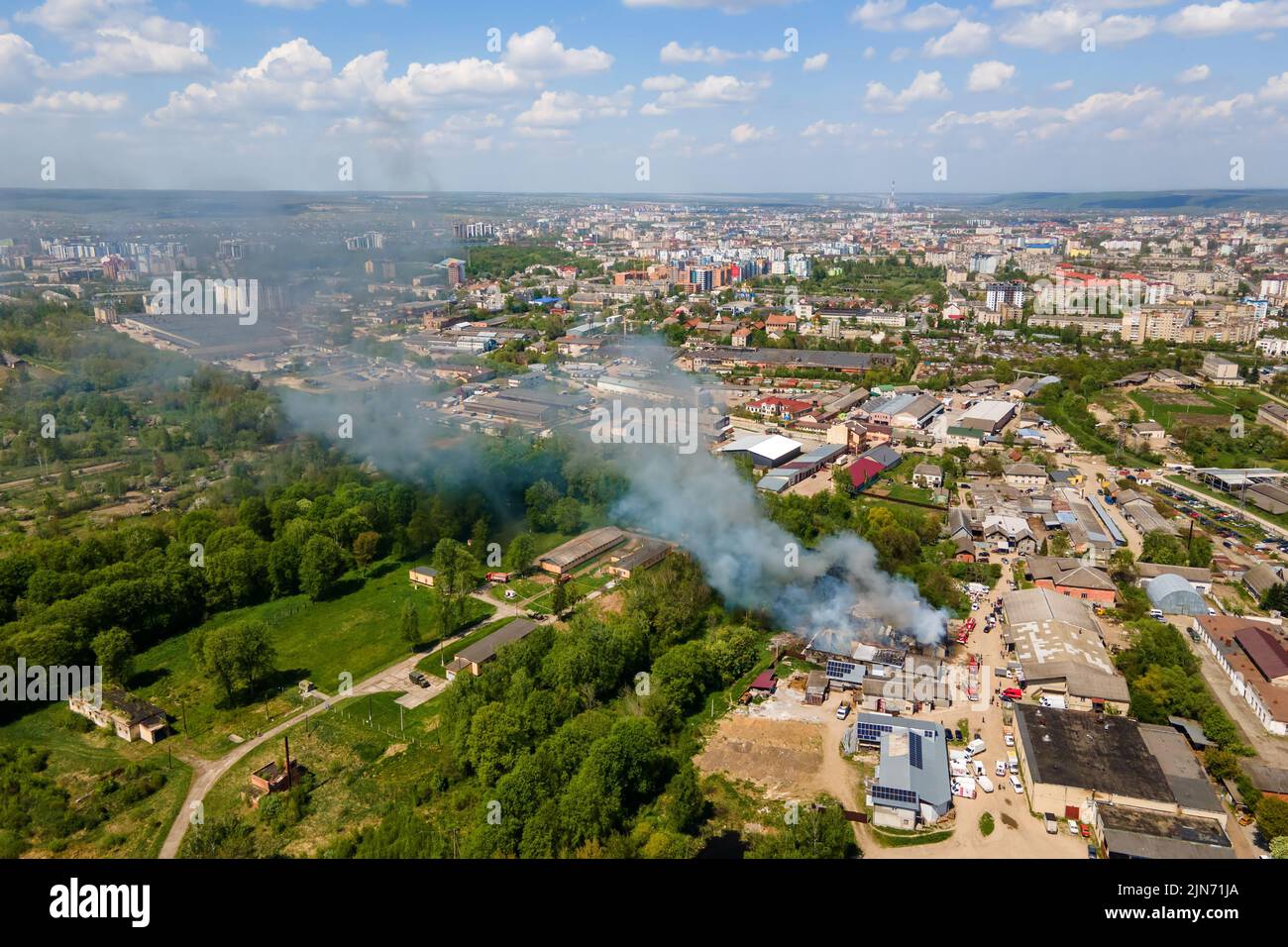 Aerial view of firefighters extinguishing ruined building on fire with ...